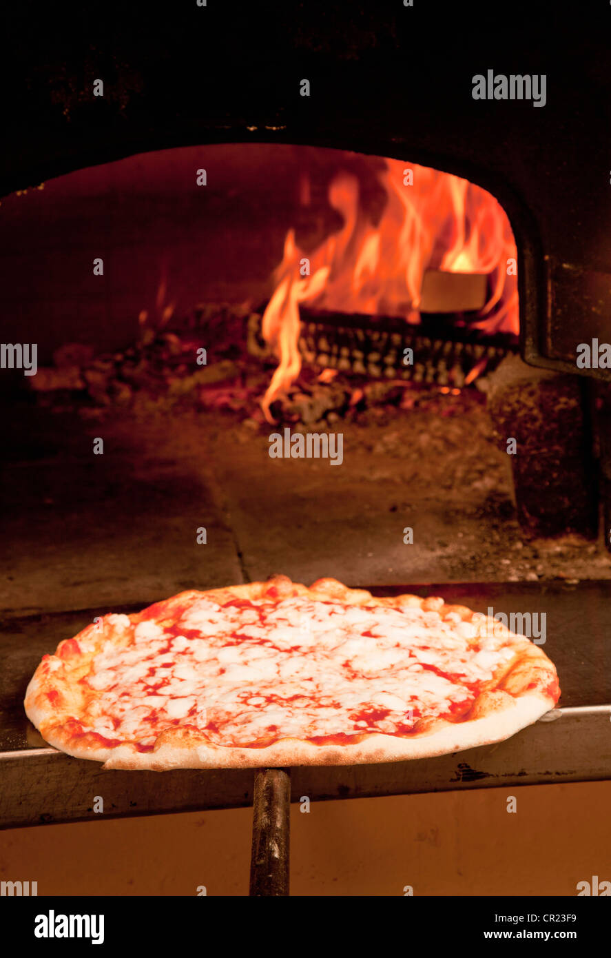 Chef pulling pizza from oven Stock Photo - Alamy