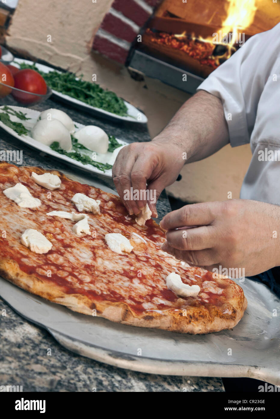 Chef garnishing pizza with cheese Stock Photo - Alamy