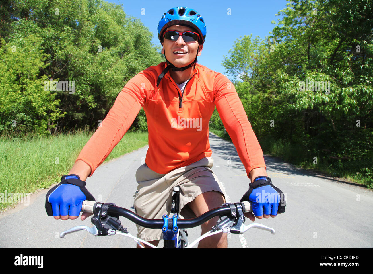 Portrait of a handsome man riding a bike Stock Photo - Alamy