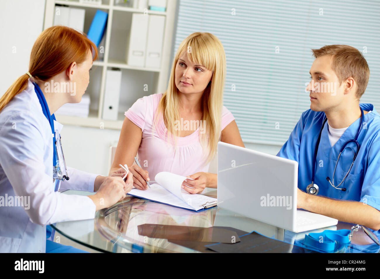 Portrait of confident practitioner consulting patient in hospital Stock ...