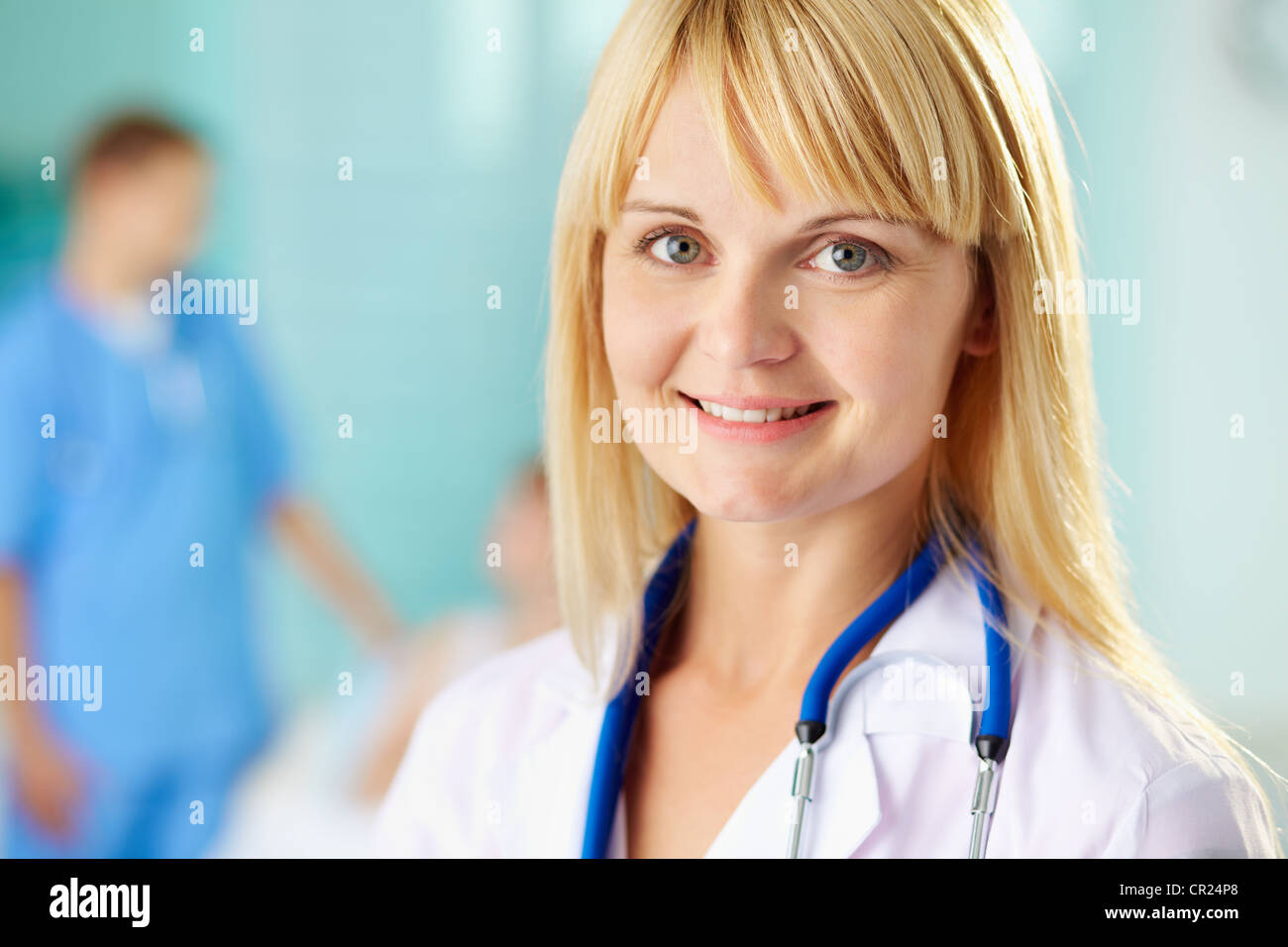 Portrait of smiling female practitioner looking at camera in hospital ...