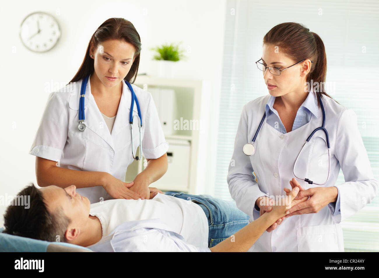 Female practitioners examining the patient looking for the source of ...