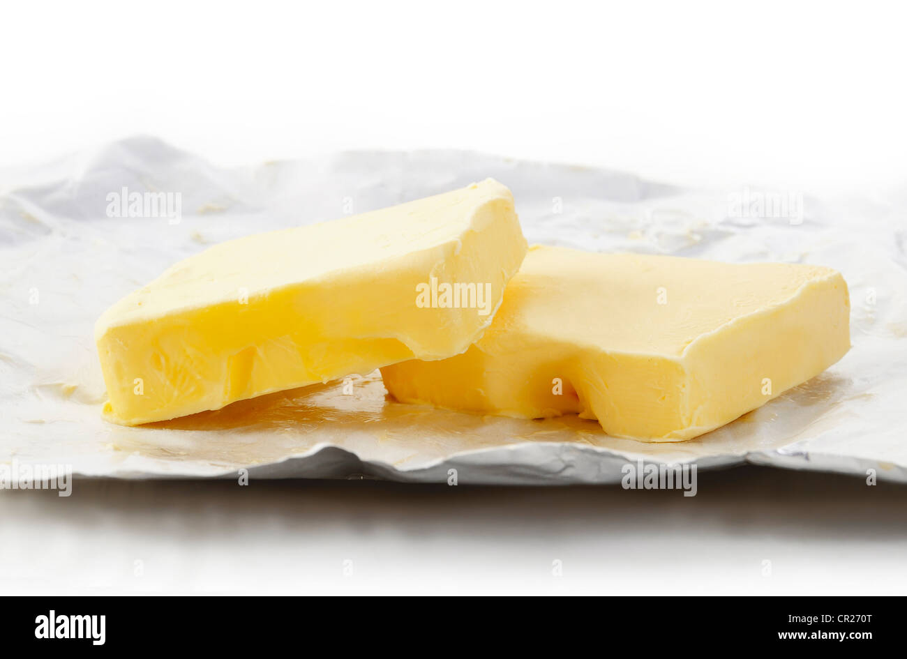 Piece of butter in paper on white background Stock Photo - Alamy