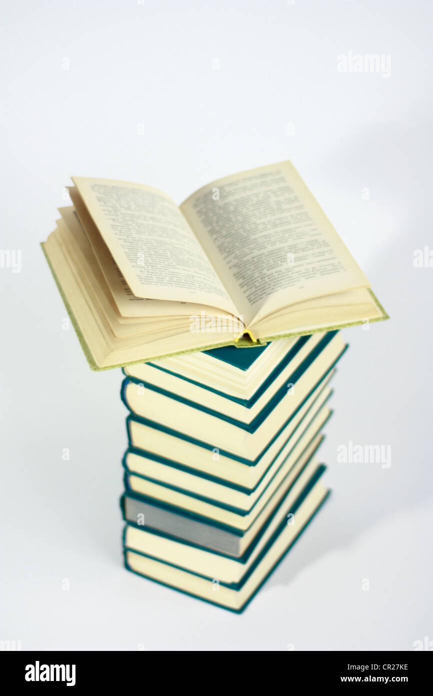 Opened book on stack Stock Photo - Alamy