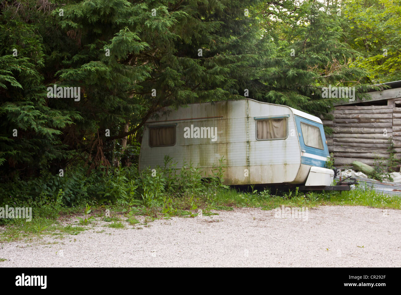 Old Sprite musketeer caravan abandoned and left to rot under some trees ...