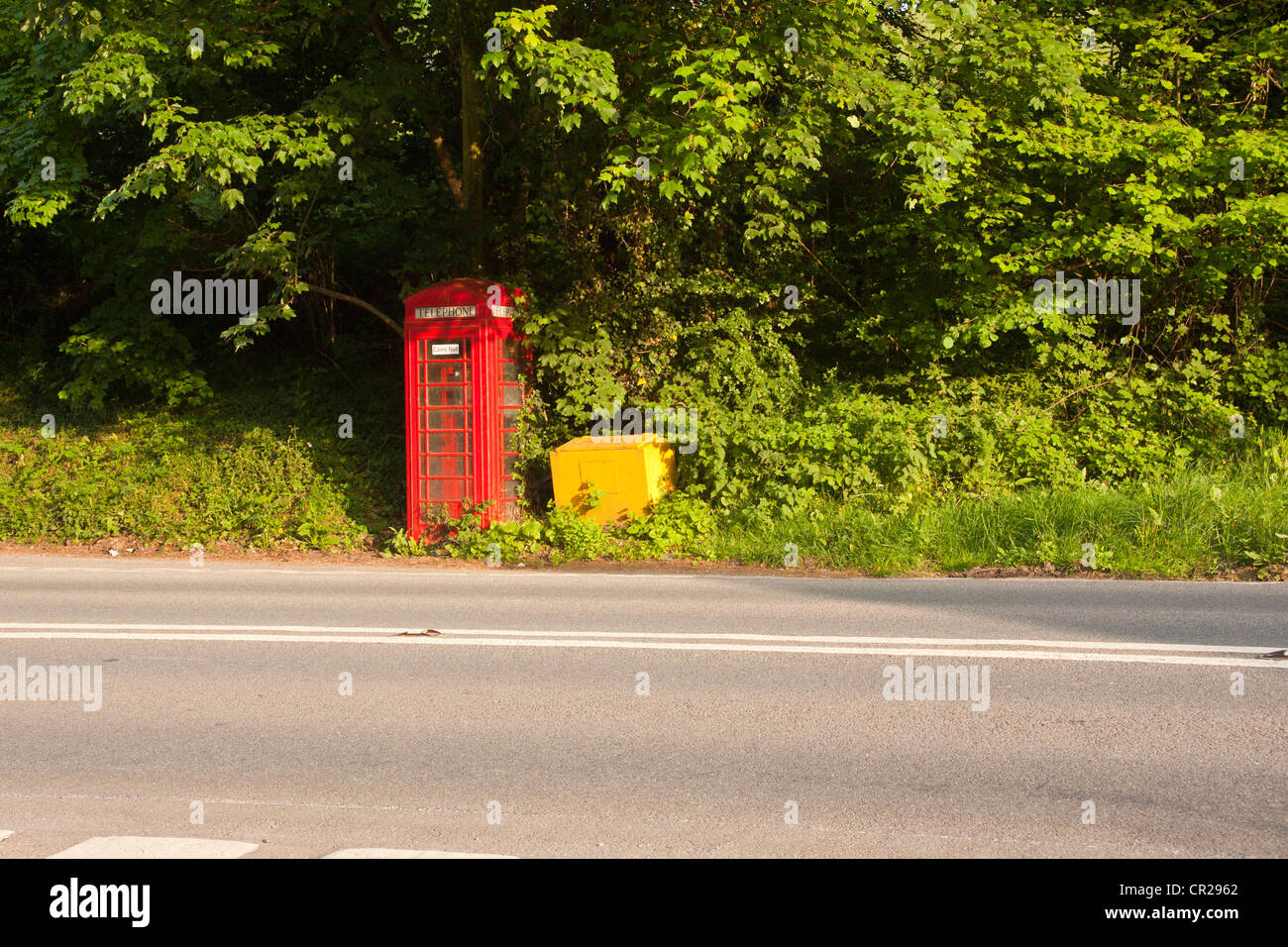 Old fashioned red telephone box with yellow grit container on Devon ...