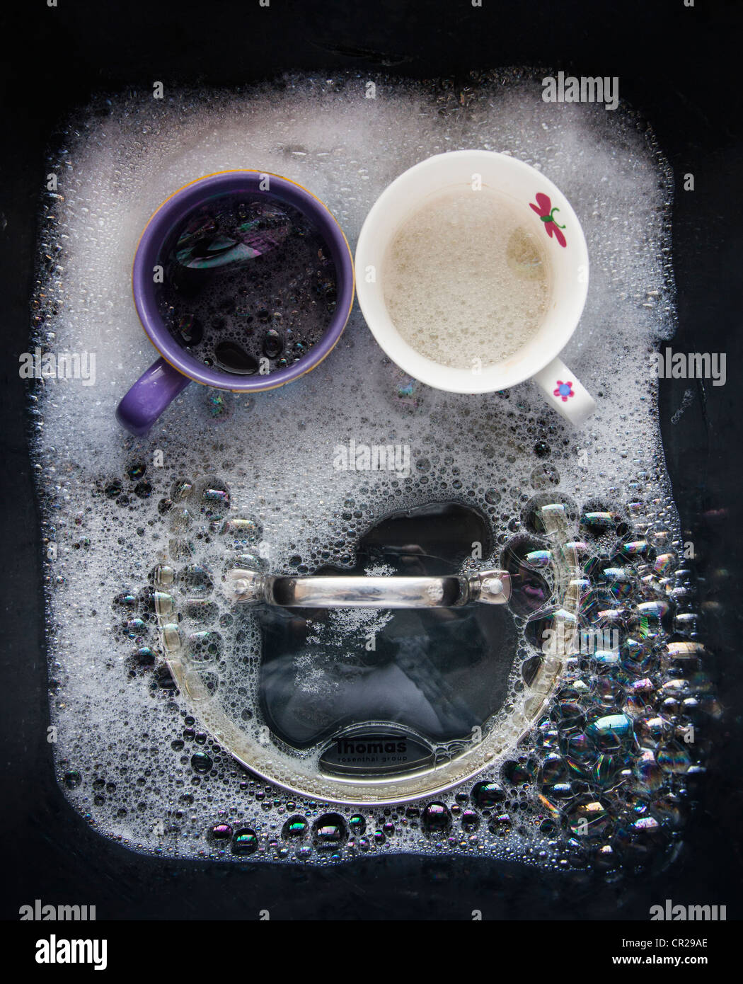 Crockery in a washing up bowl takes on the appearance of a face Stock ...