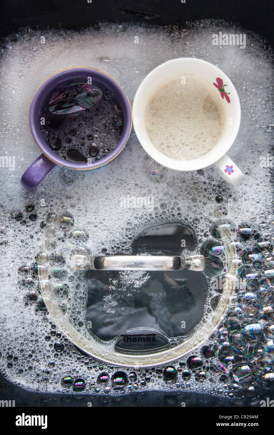 Crockery in a washing up bowl takes on the appearance of a face Stock ...