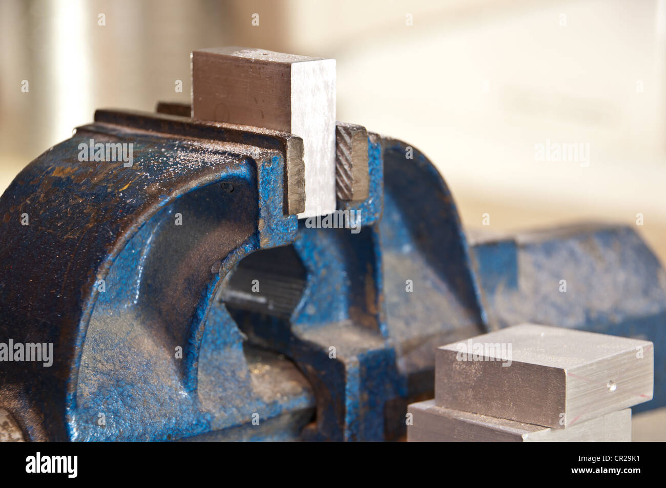Vice with a block of metal on a wooden workbench Stock Photo - Alamy