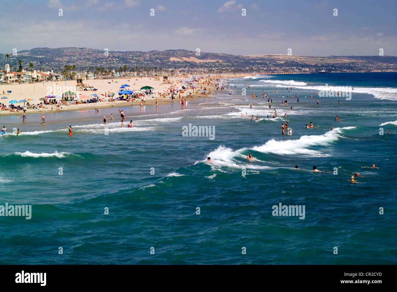 Summertime beachgoers and swimmers enjoy the Pacific Ocean surf along ...