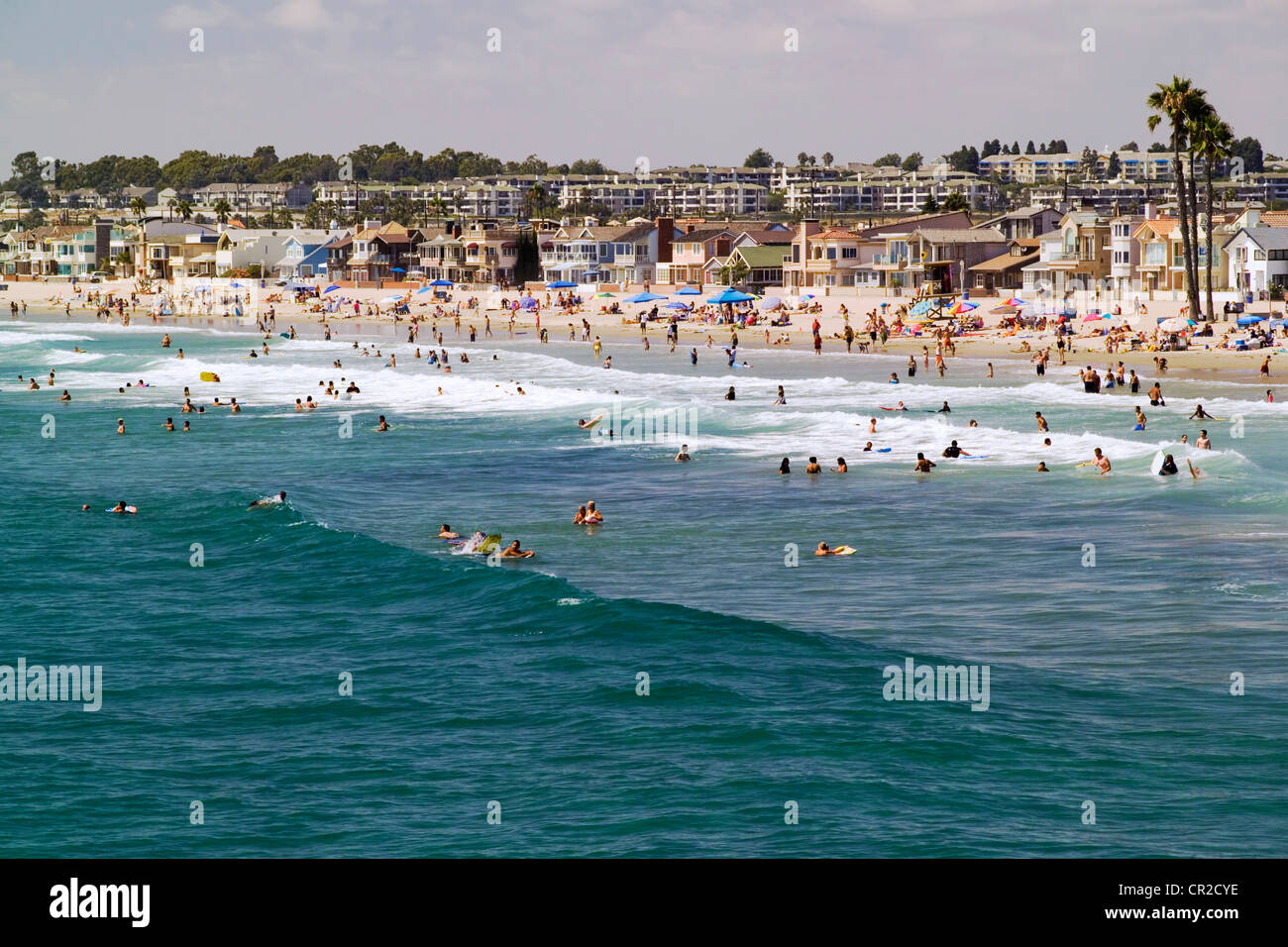 Summertime beachgoers and swimmers enjoy the Pacific Ocean surf along ...
