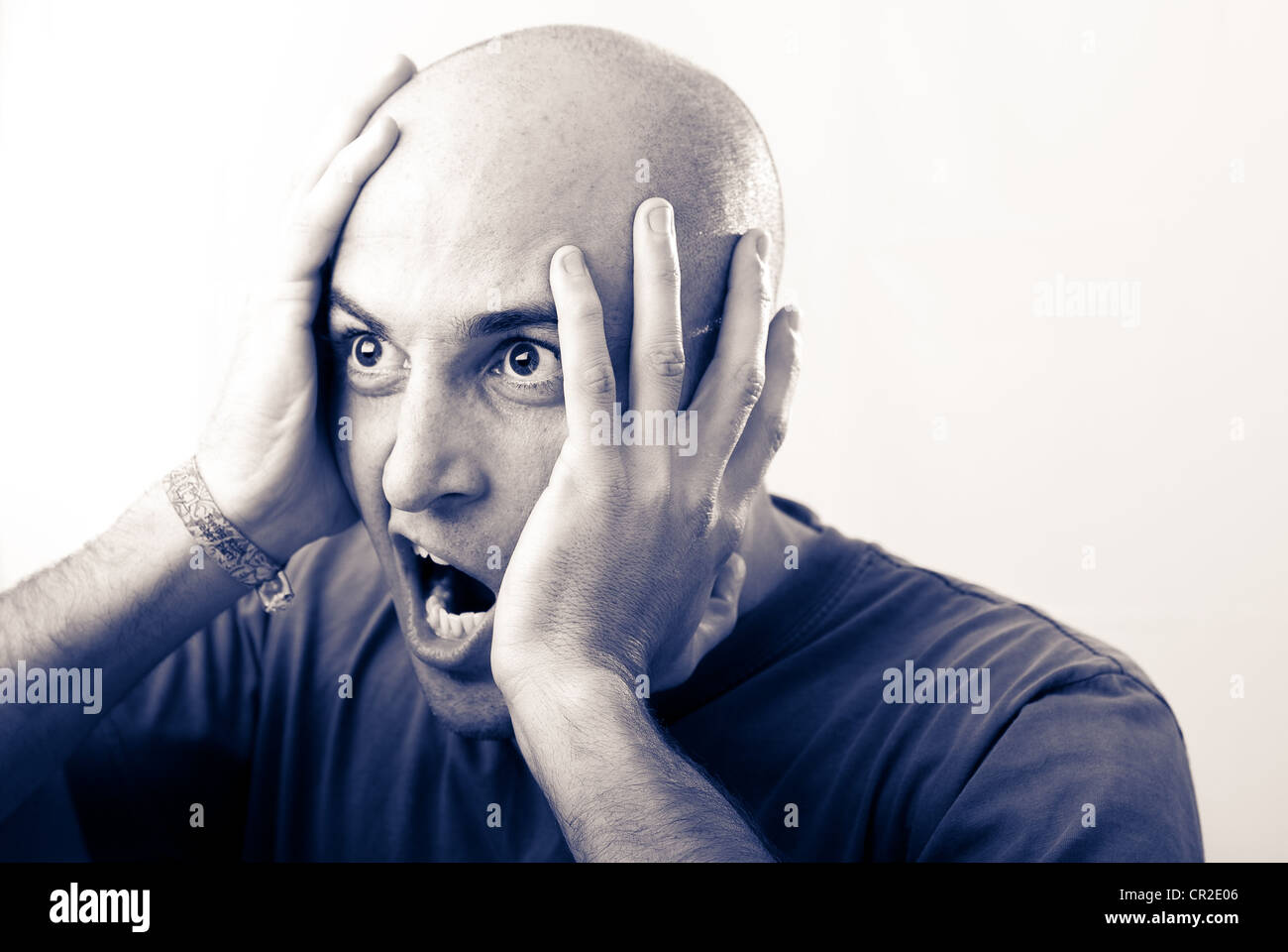 Man holding head with furious mad crazy expression Stock Photo - Alamy