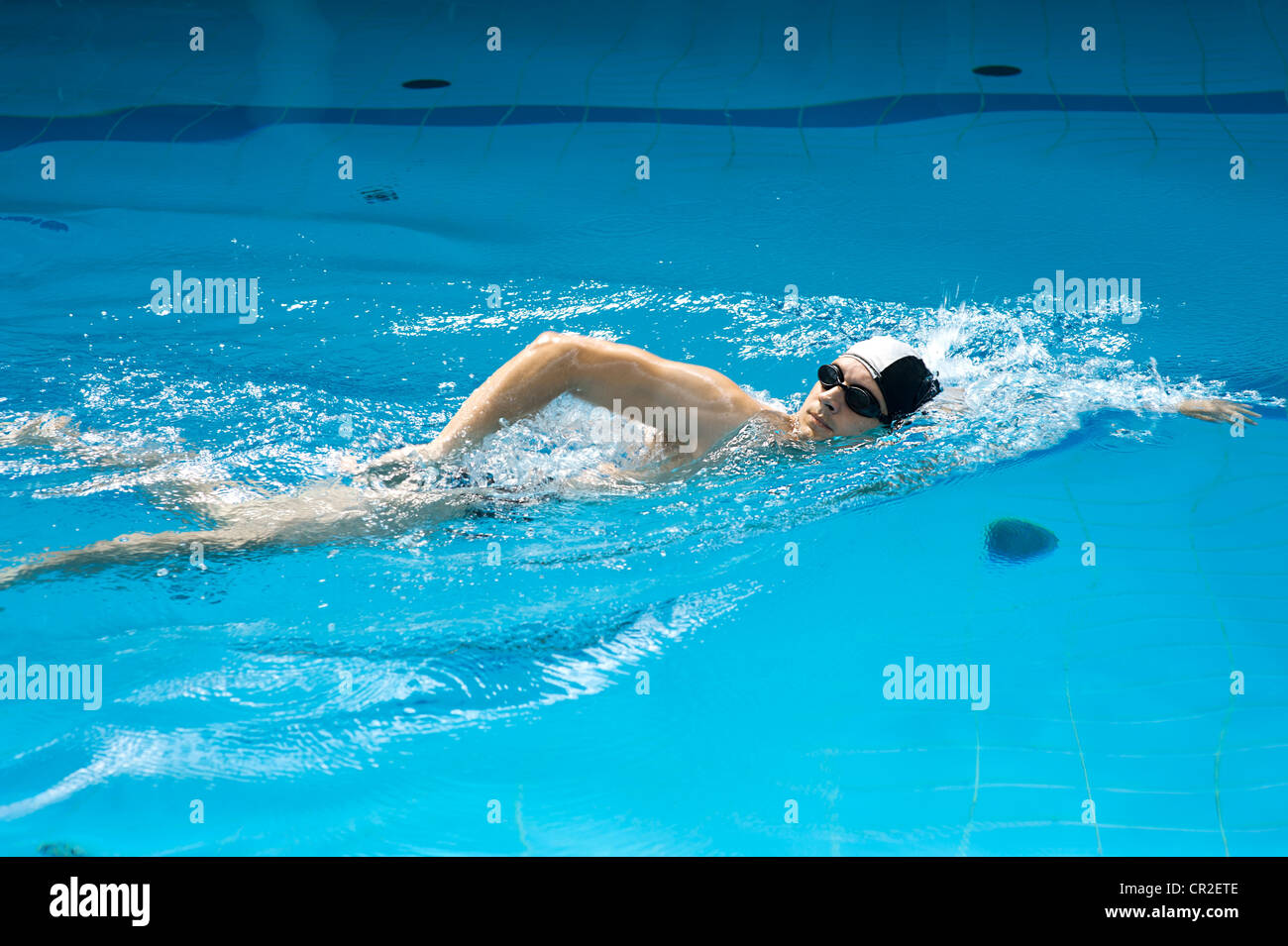 Male Swimmer performing the crawl stroke at blue water pool Stock Photo ...