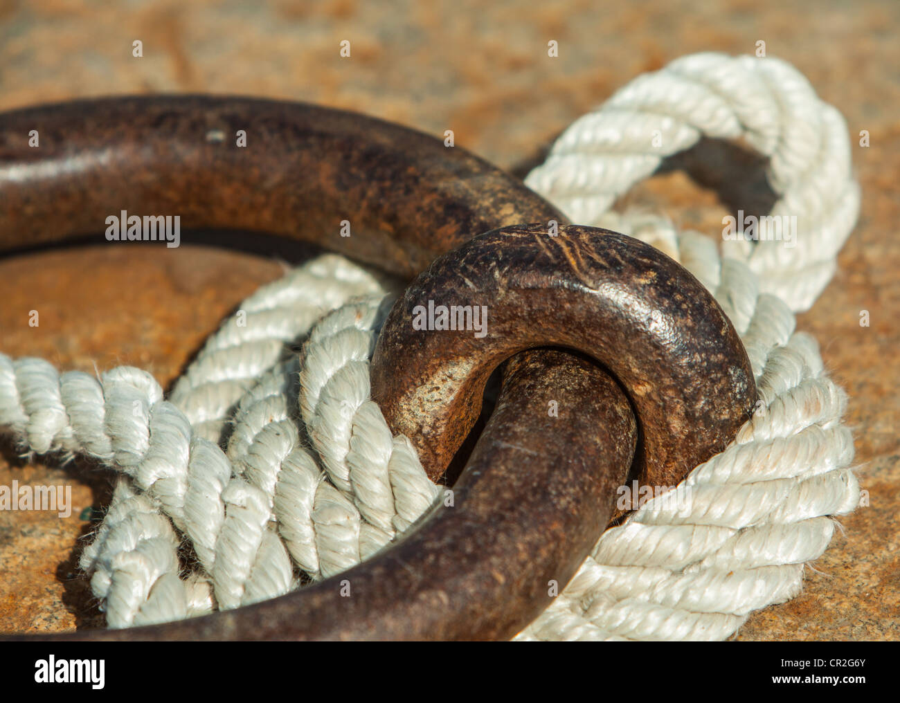 Mooring rope fastened to eye on harbour wall Stock Photo - Alamy