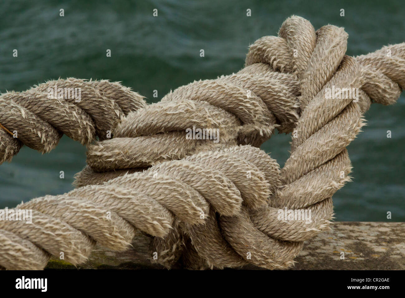 Mooring rope fastened to eye on harbour wall Stock Photo - Alamy