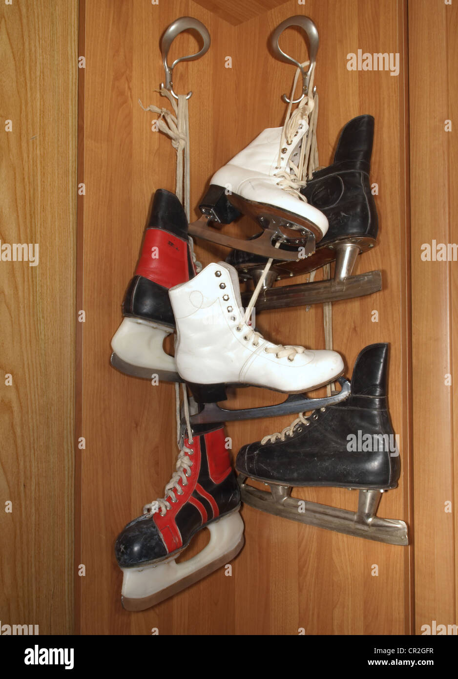 Three pairs of old skates hanging in the closet Stock Photo - Alamy