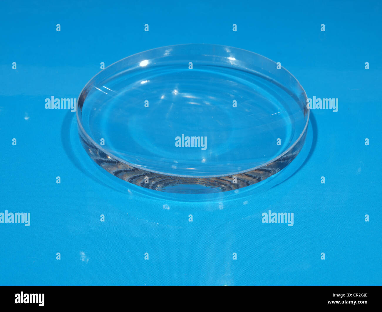 Glass lens on a blue background Stock Photo - Alamy