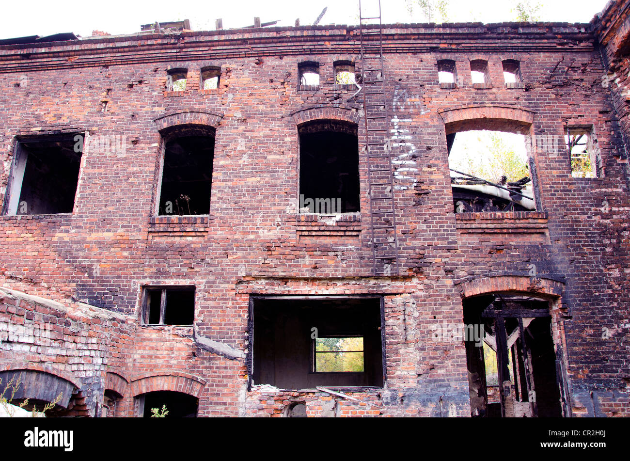 old abandoned building after fire. ladders window and door arches ...