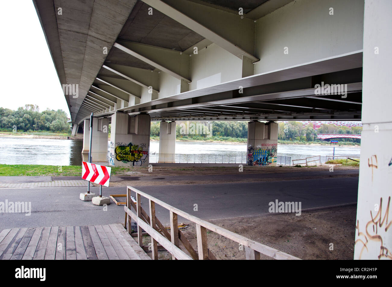 road sign indicating direction of movement under large metal bridge ...