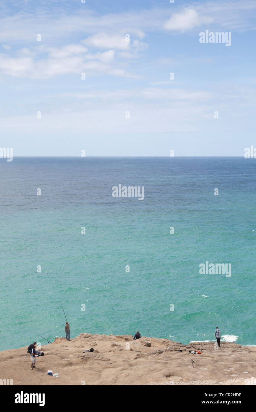 People fishing on a cliff at Castlepoint, Wairarapa coast, Wellington ...