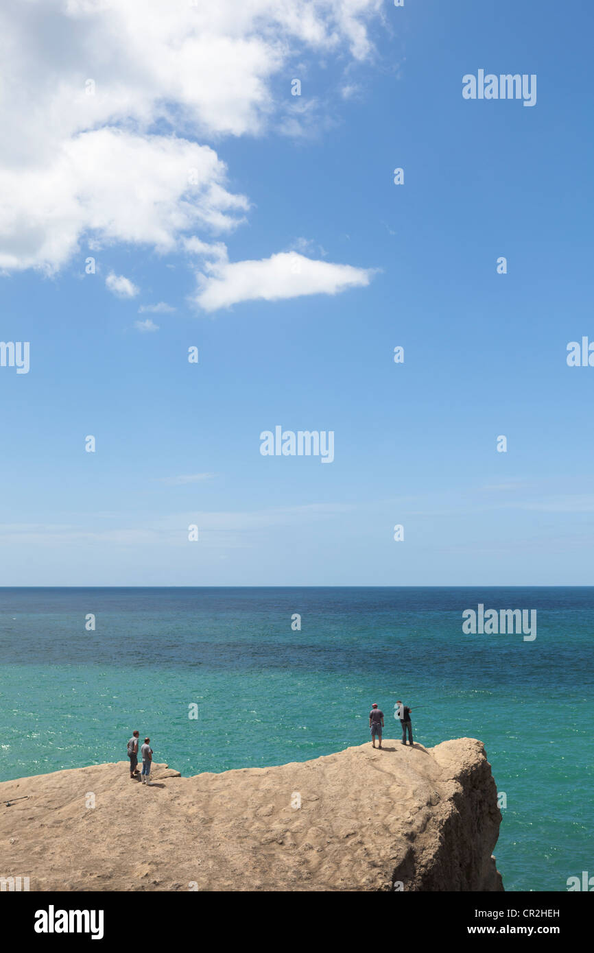 People fishing on a cliff at Castlepoint, Wairarapa coast, Wellington ...