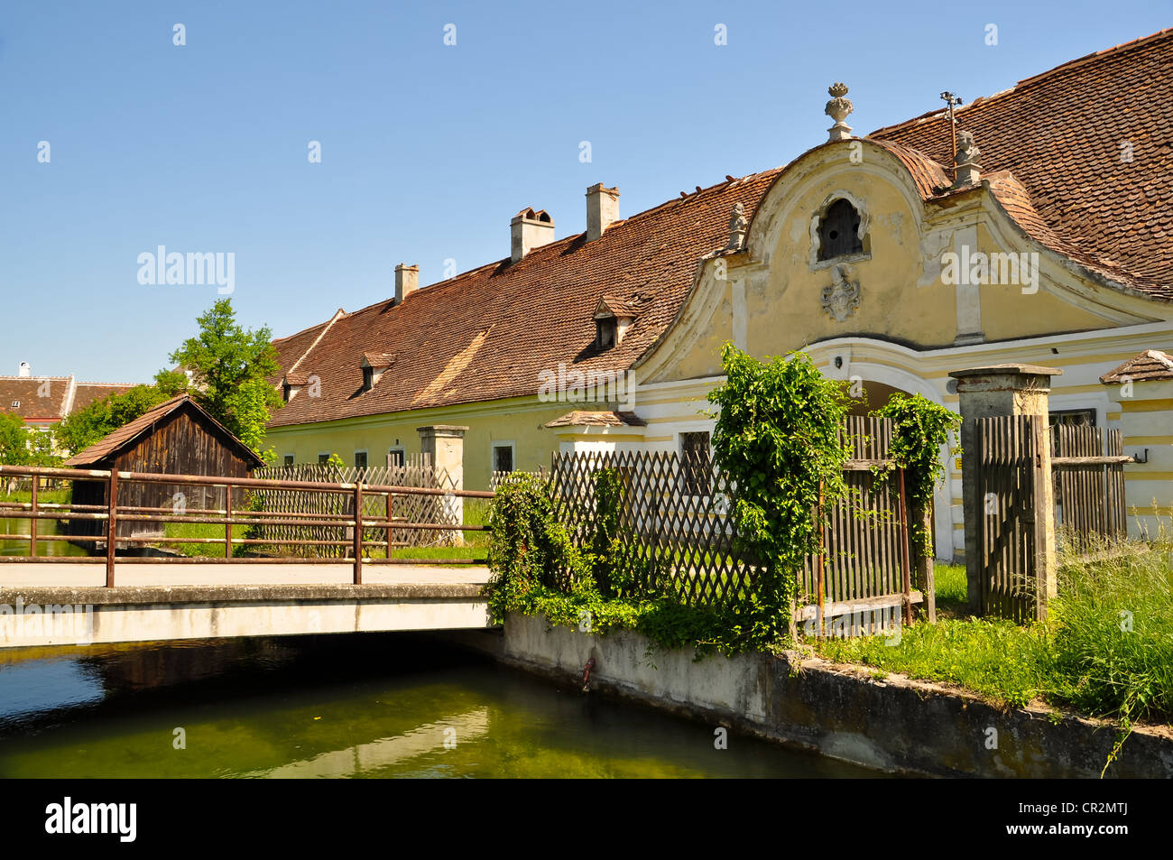 frontside of an old yellow manor with a bridge Stock Photo - Alamy
