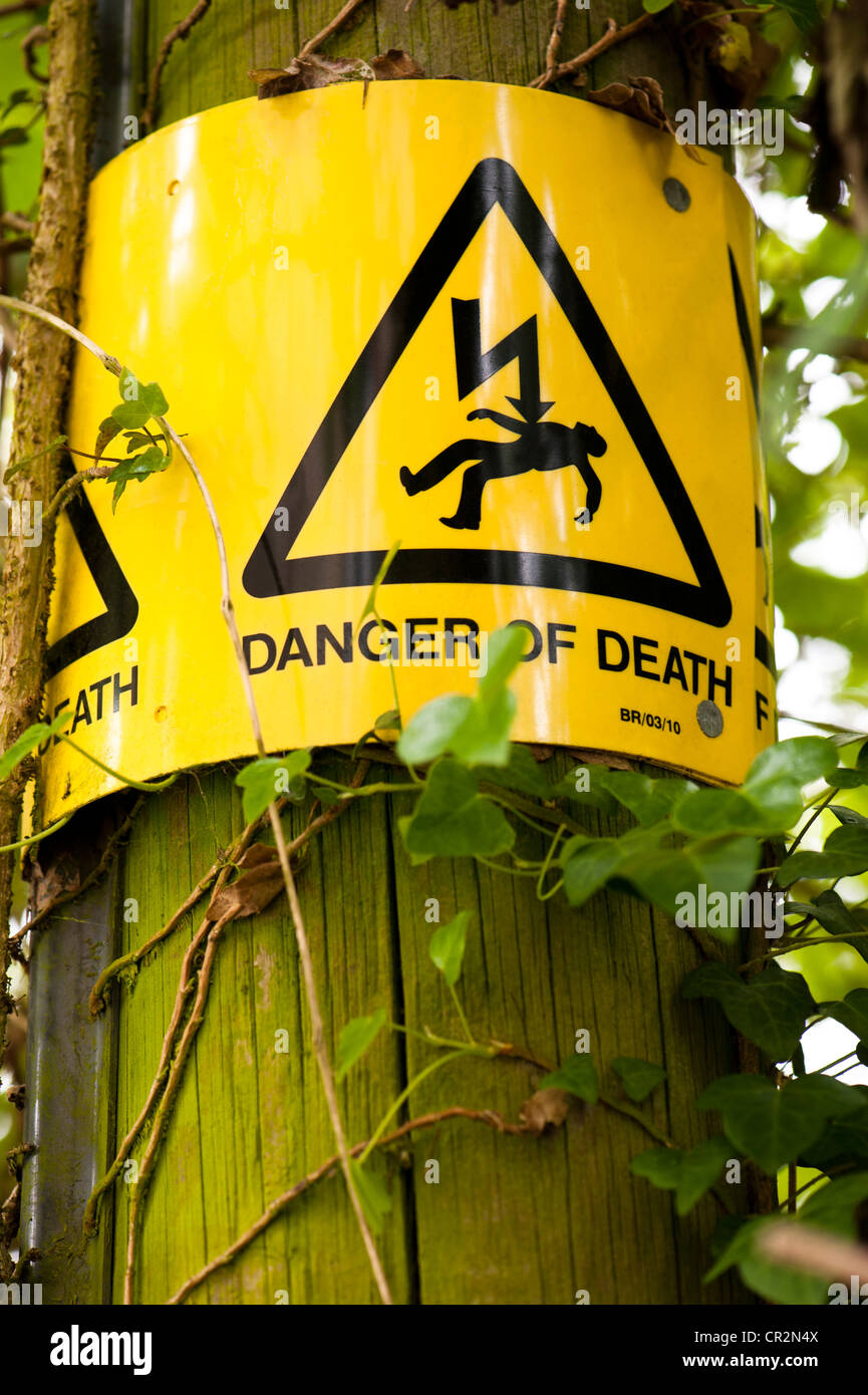 Danger of death by electrocution warning sign on a wooden pole Stock ...