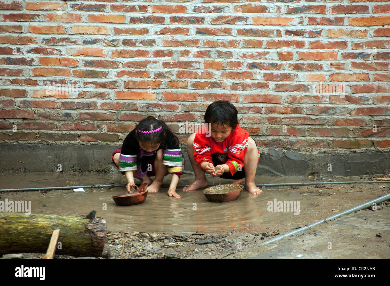 Two Chinese kids playing in a puddle with pans, Gaozheng Dong Village ...