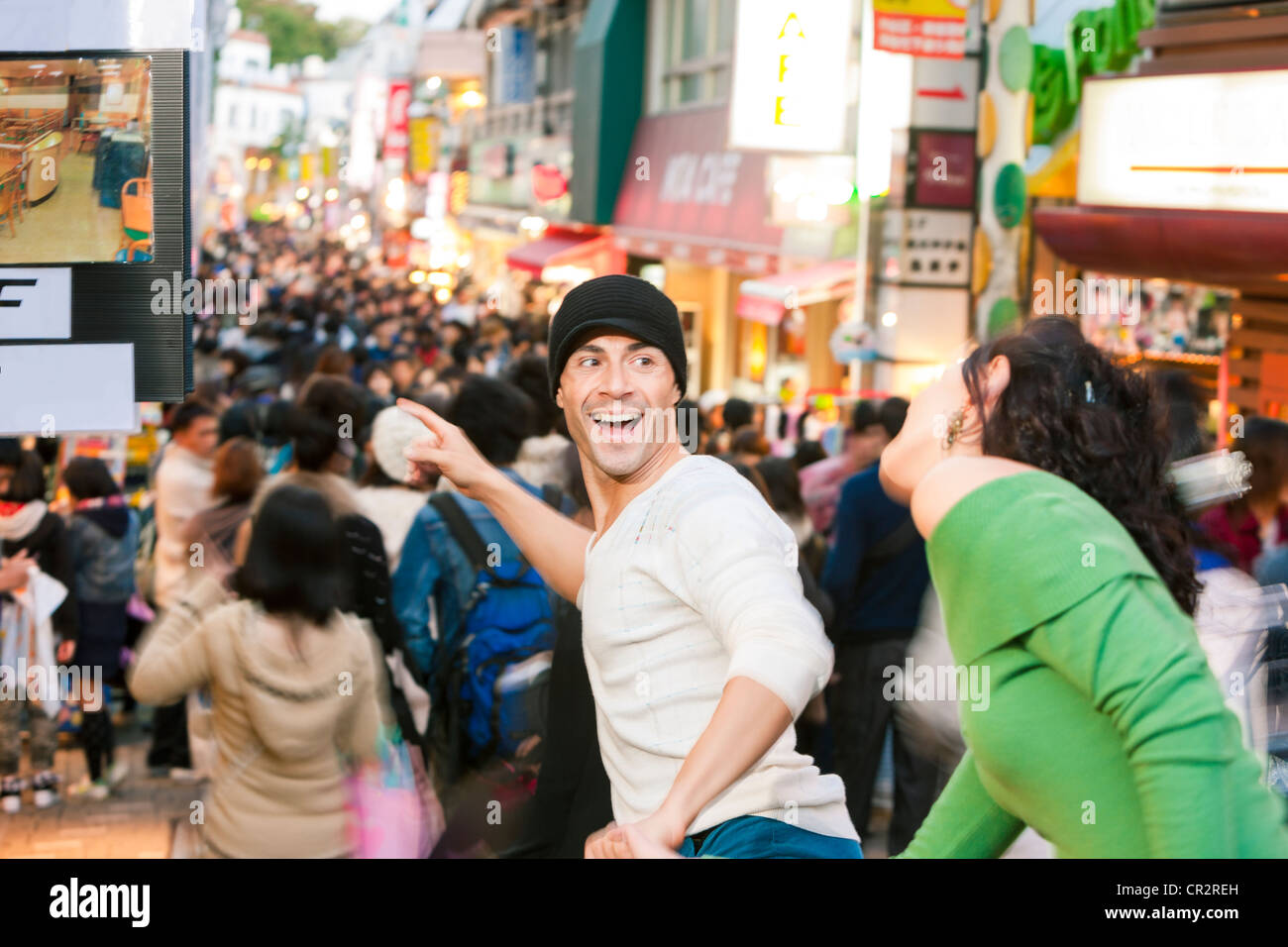 Man and woman energetically run into a crowded city street Stock Photo ...