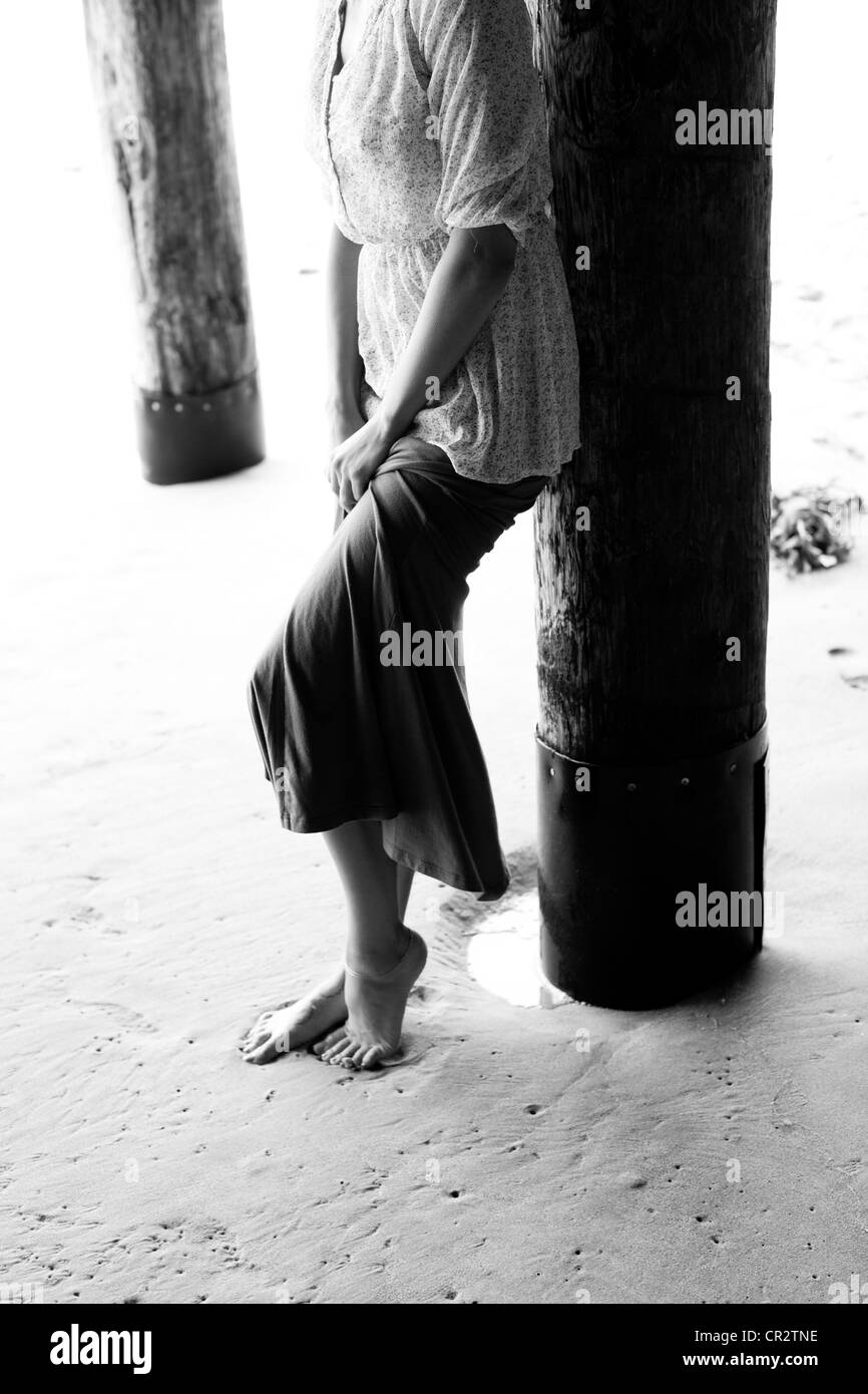 woman's feet in the sand under the pier Stock Photo - Alamy