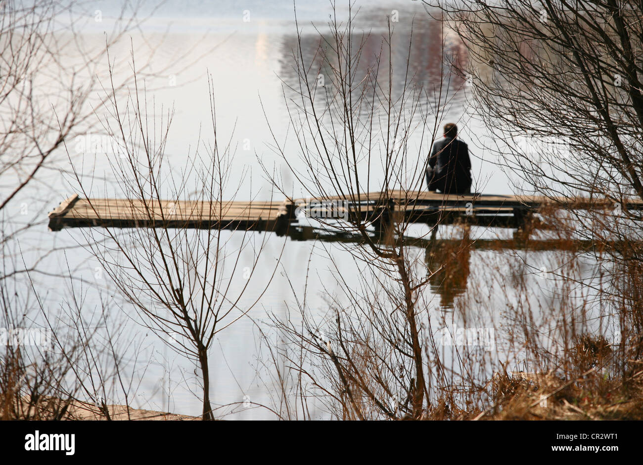 The image lonely man sitting on the bridge Stock Photo - Alamy