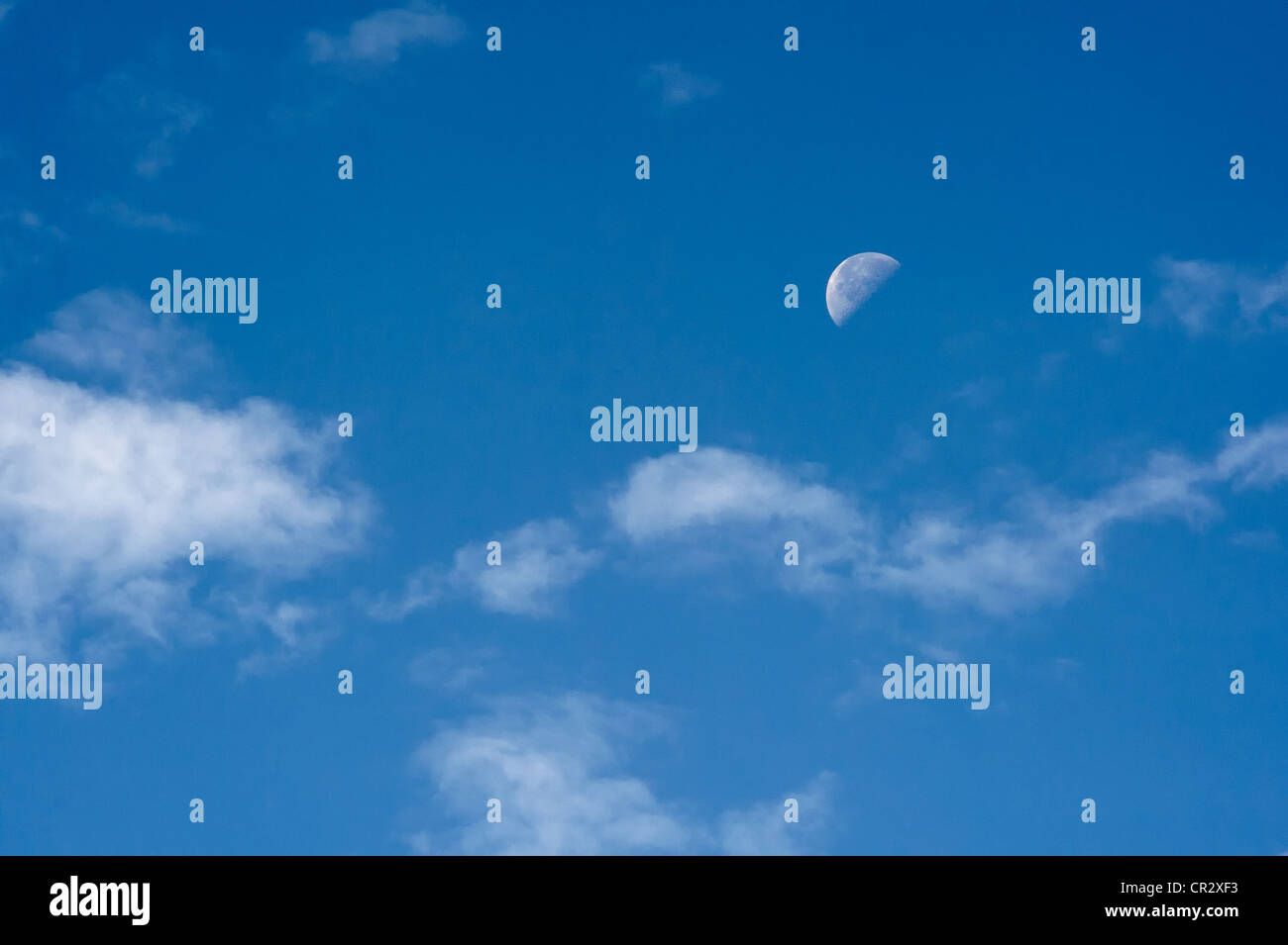 Bright blue morning sky with the half moon and clouds Stock Photo - Alamy