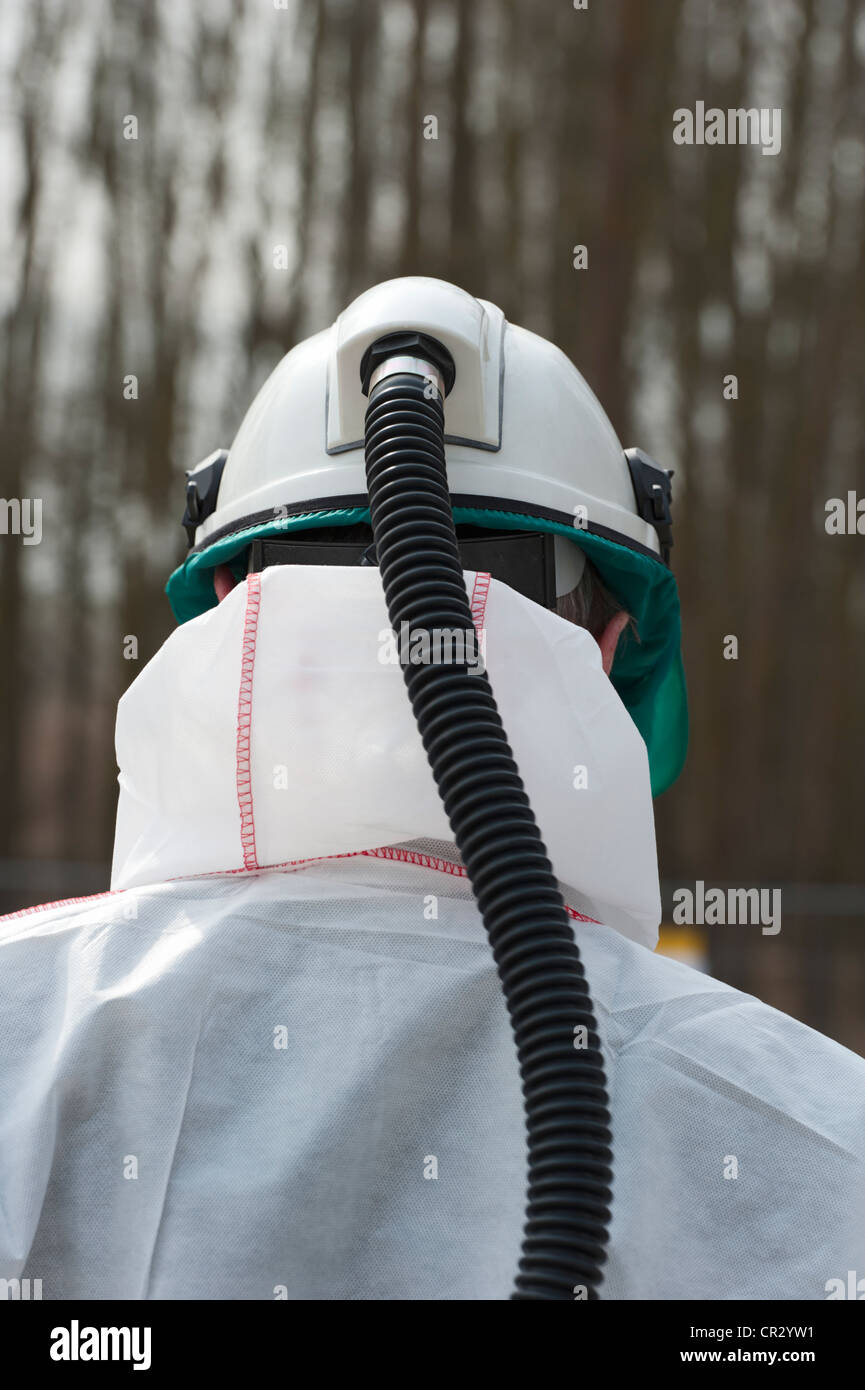 Worker wearing a respiratory protection filter device at a toxic waste ...