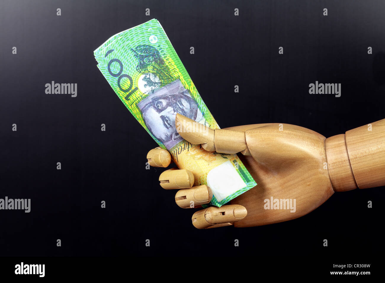 Fake Australian One Hundred Dollar currency in a mannequins wooden hand ...