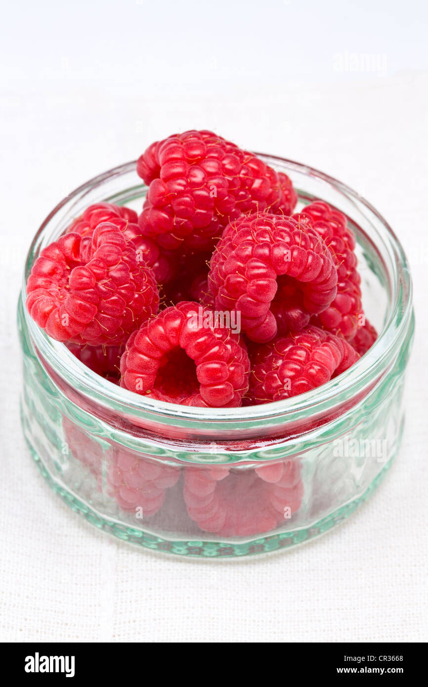 Raspberries on a white background in a glass container Stock Photo - Alamy