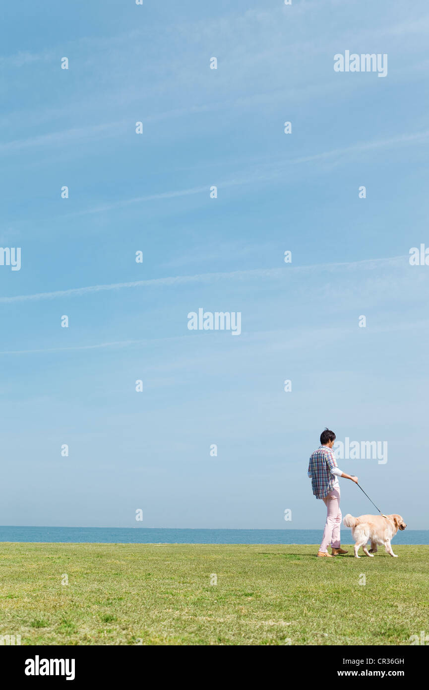 Man Walking With Dog on Grass Stock Photo - Alamy