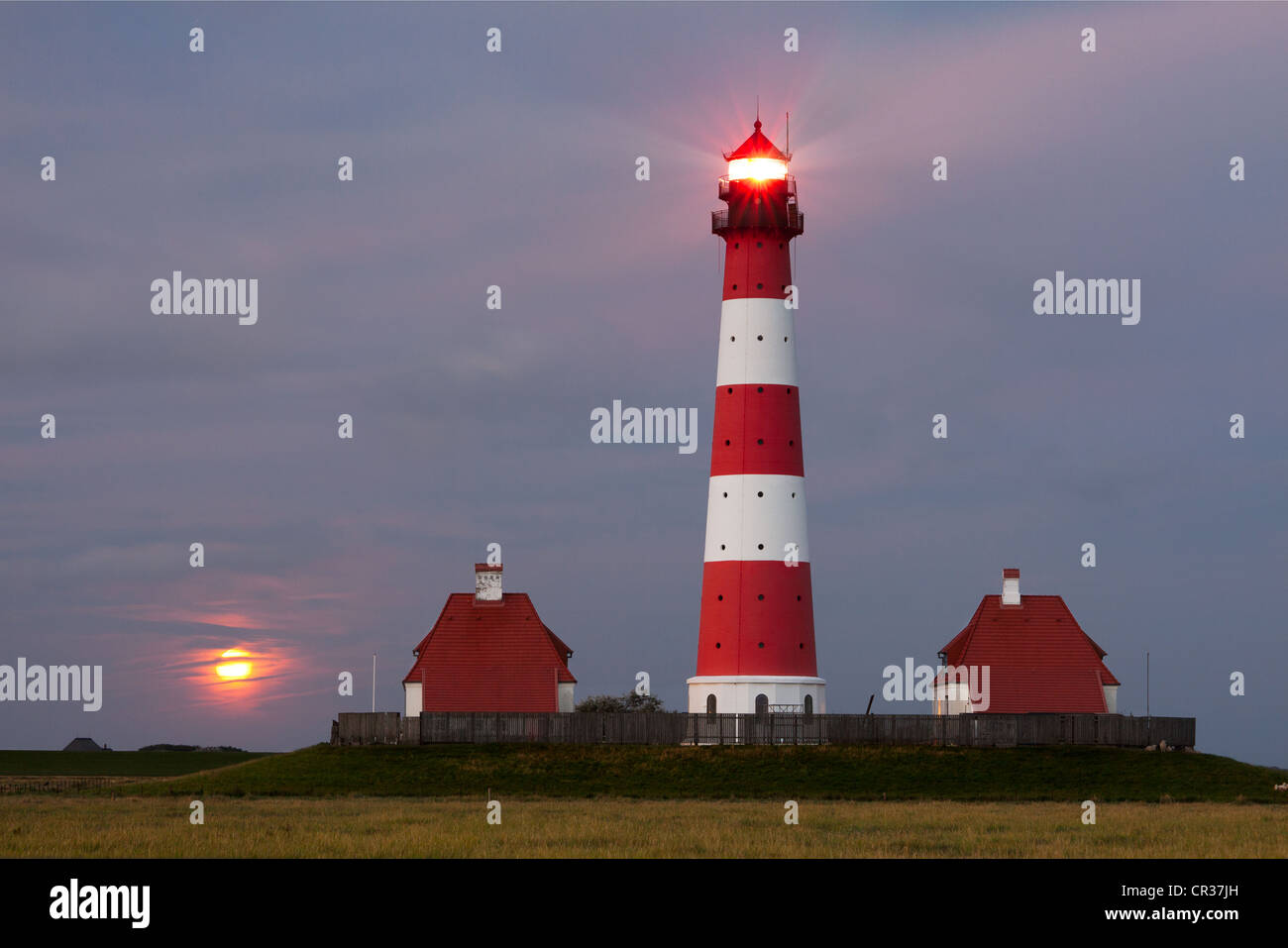 Westerhever lighthouse with the full moon rising above the horizon ...