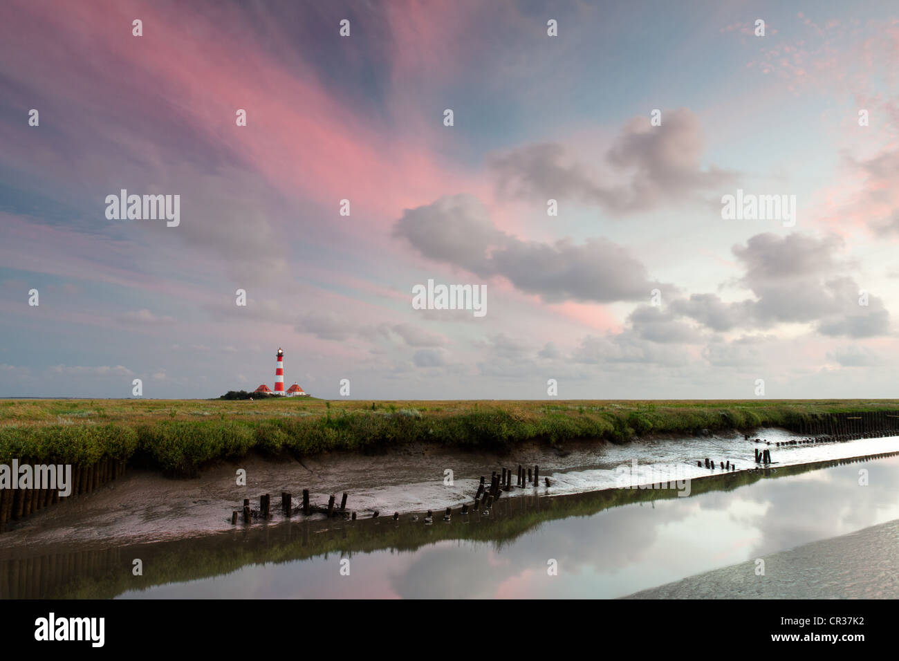 Westerhever lighthouse with a tidal gully at front shortly after sunset ...