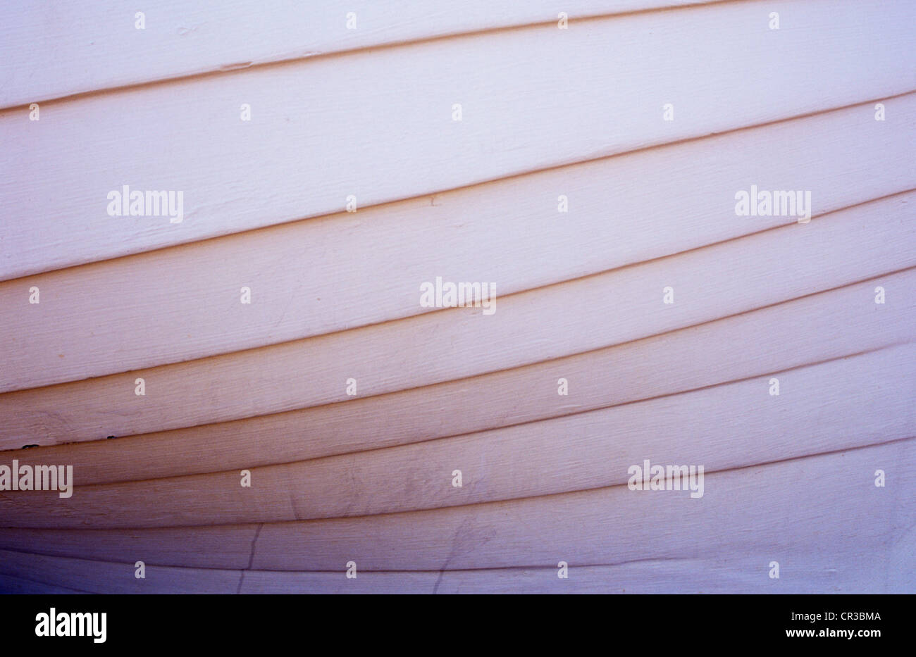 Detail of hull of white painted wooden boat with converging and curving ...
