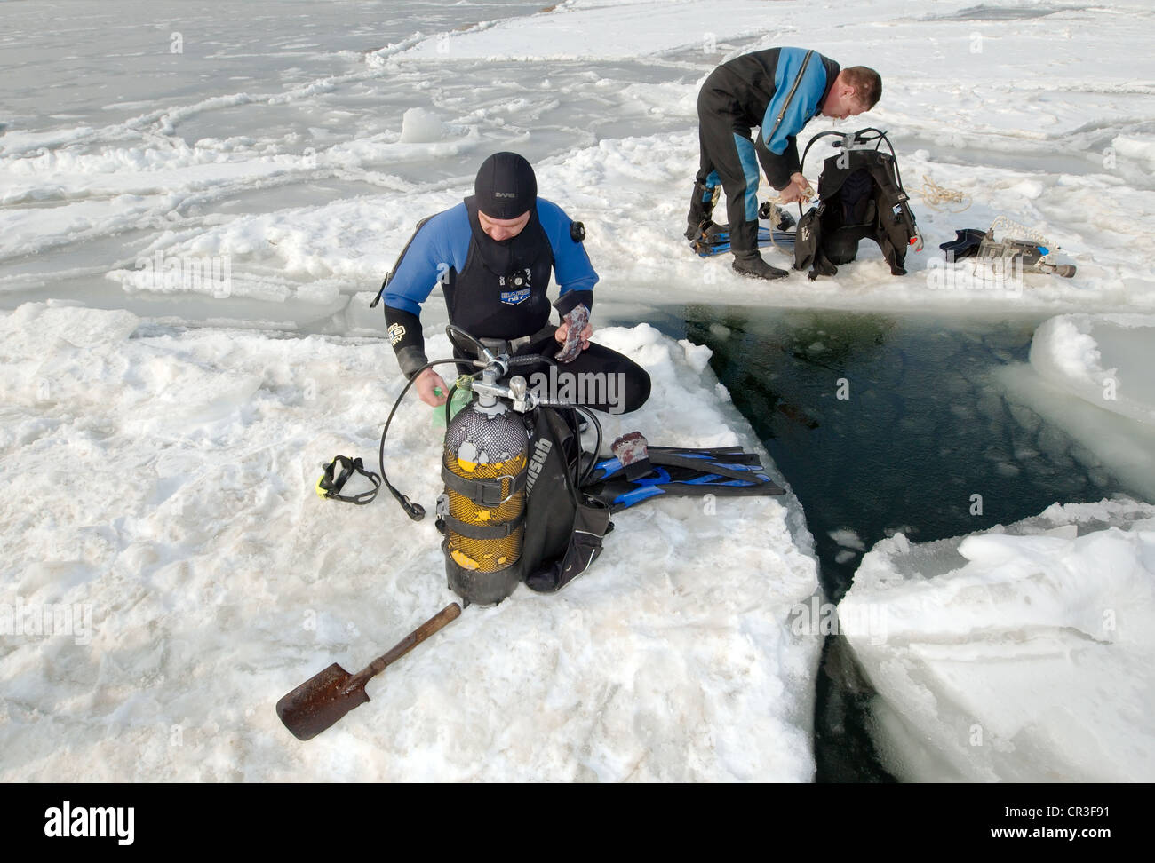 Divers, preparing for subglacial diving, ice diving, in the frozen ...