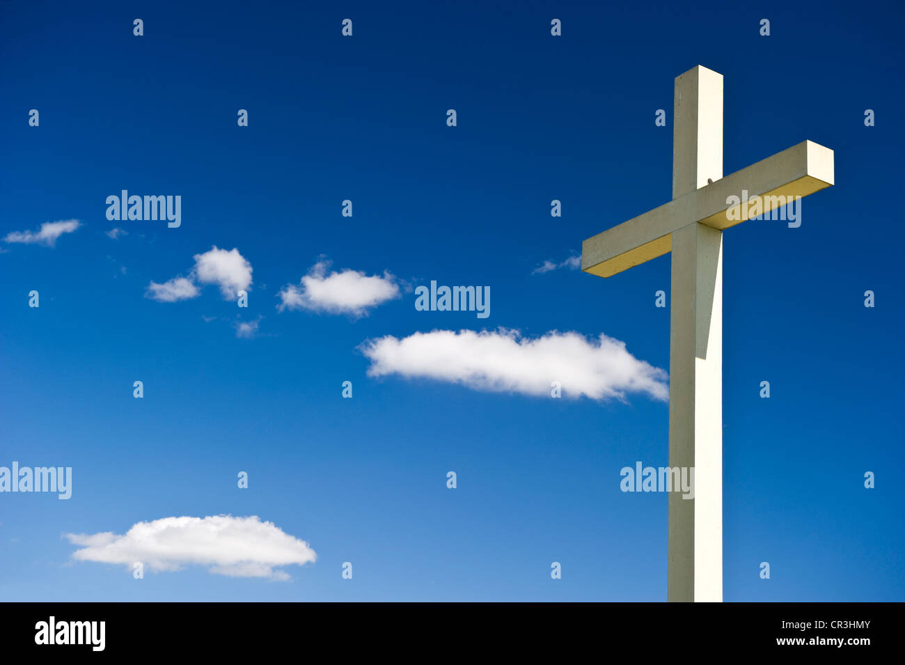 Cross against a blue sky with cumulus clouds Stock Photo - Alamy