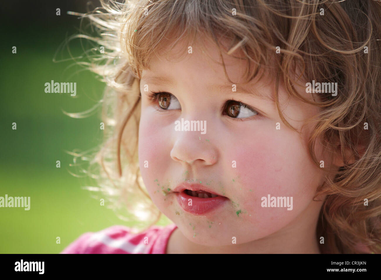 Young girl with large brown eyes and cupcake icing on her face Stock ...