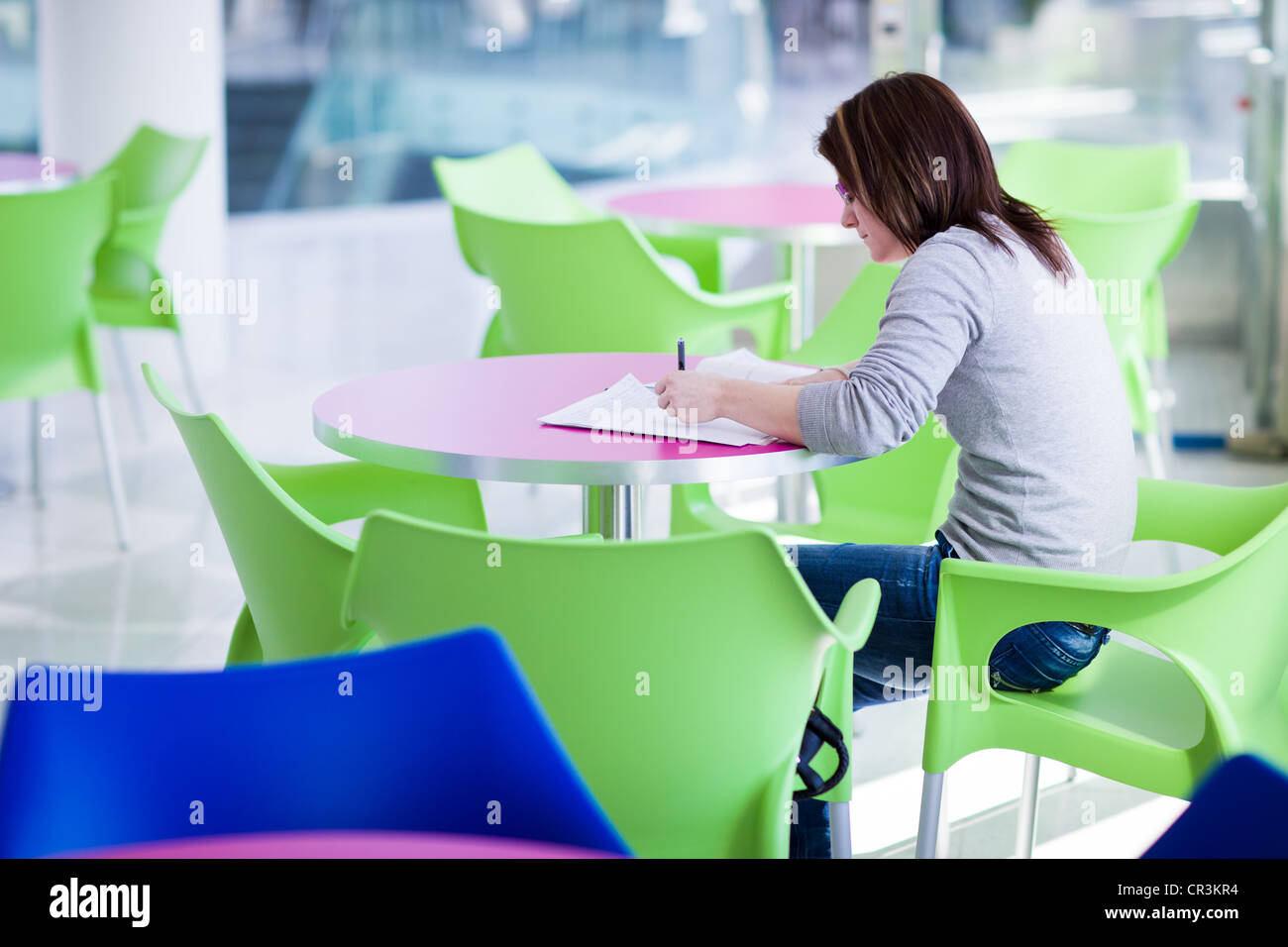 pfemale college student doing homework/assignment on campus/at scchool ...