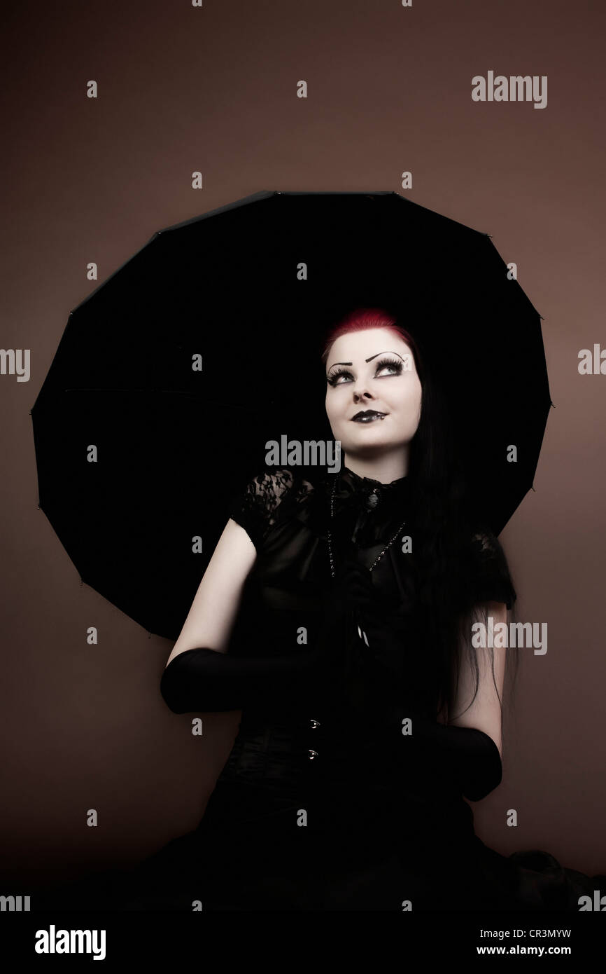 Woman, Gothic style, sitting with an umbrella Stock Photo - Alamy