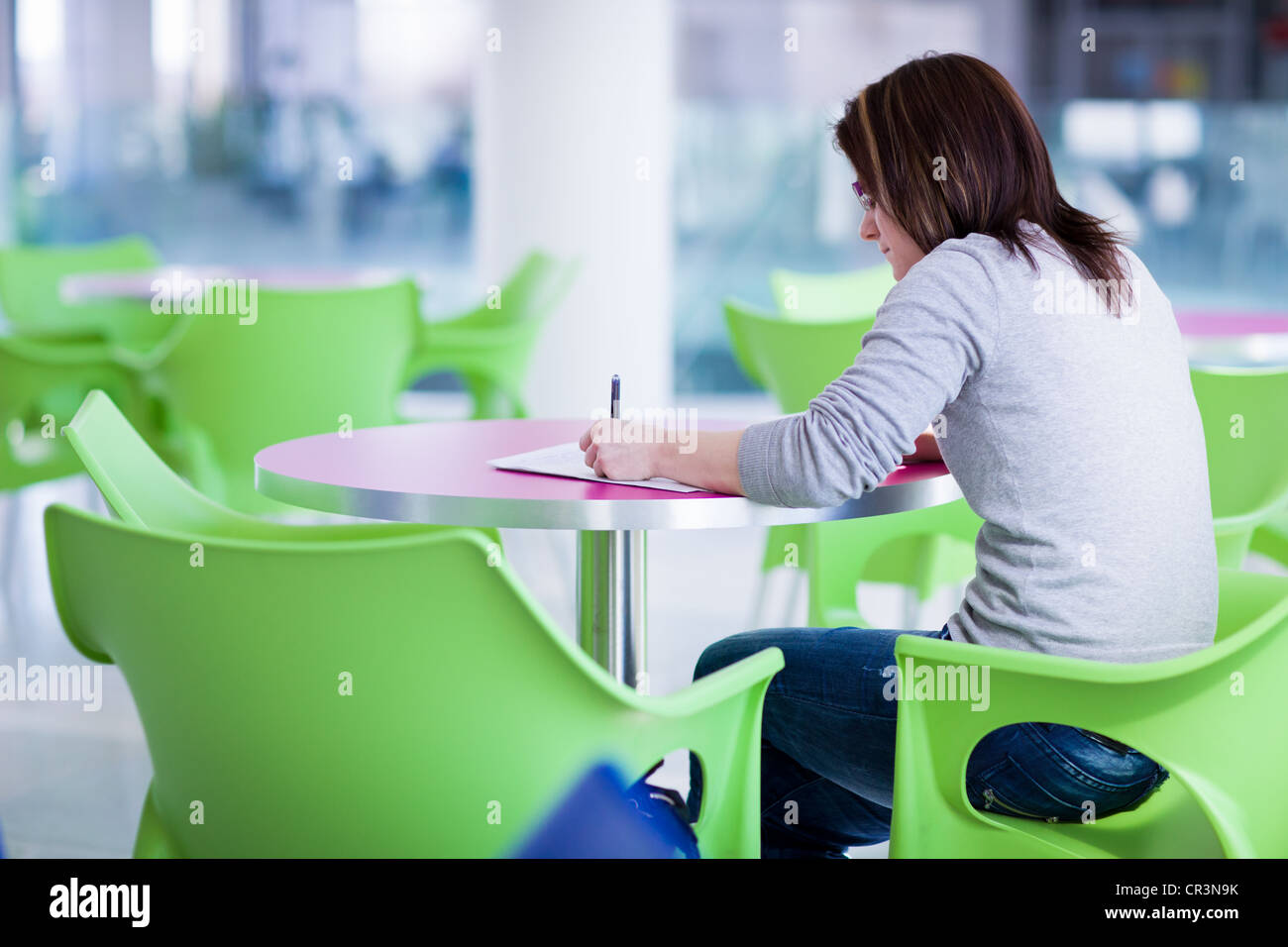 pfemale college student doing homework/assignment on campus/at scchool ...