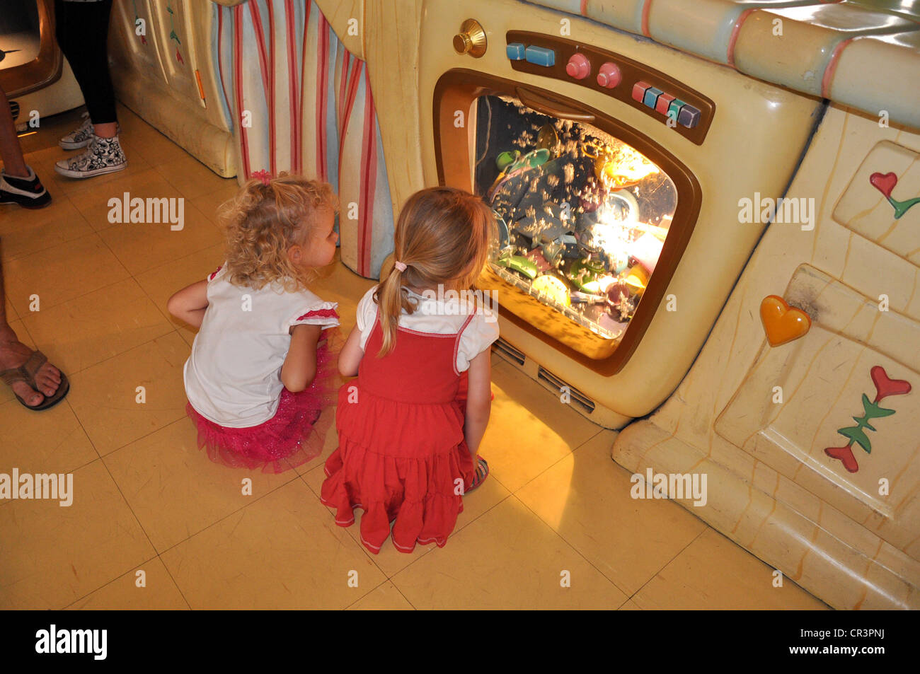 Two little girls are fascinated by the wacky dishwasher at Minnie Mouse ...