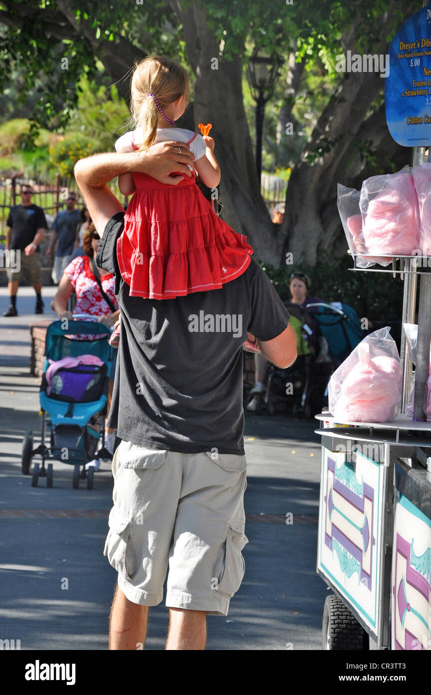 Little Girl with Mickey Mouse lollipop rides Daddy's shoulders at ...