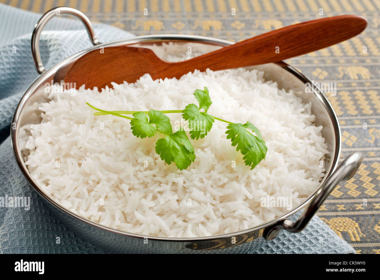 Basmati rice in a steel karahi, garnished with coriander,with a wooden ...
