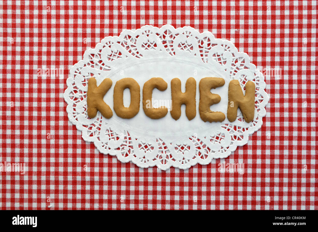 Kochen or cooking written in alphabet biscuits on paper doily Stock ...