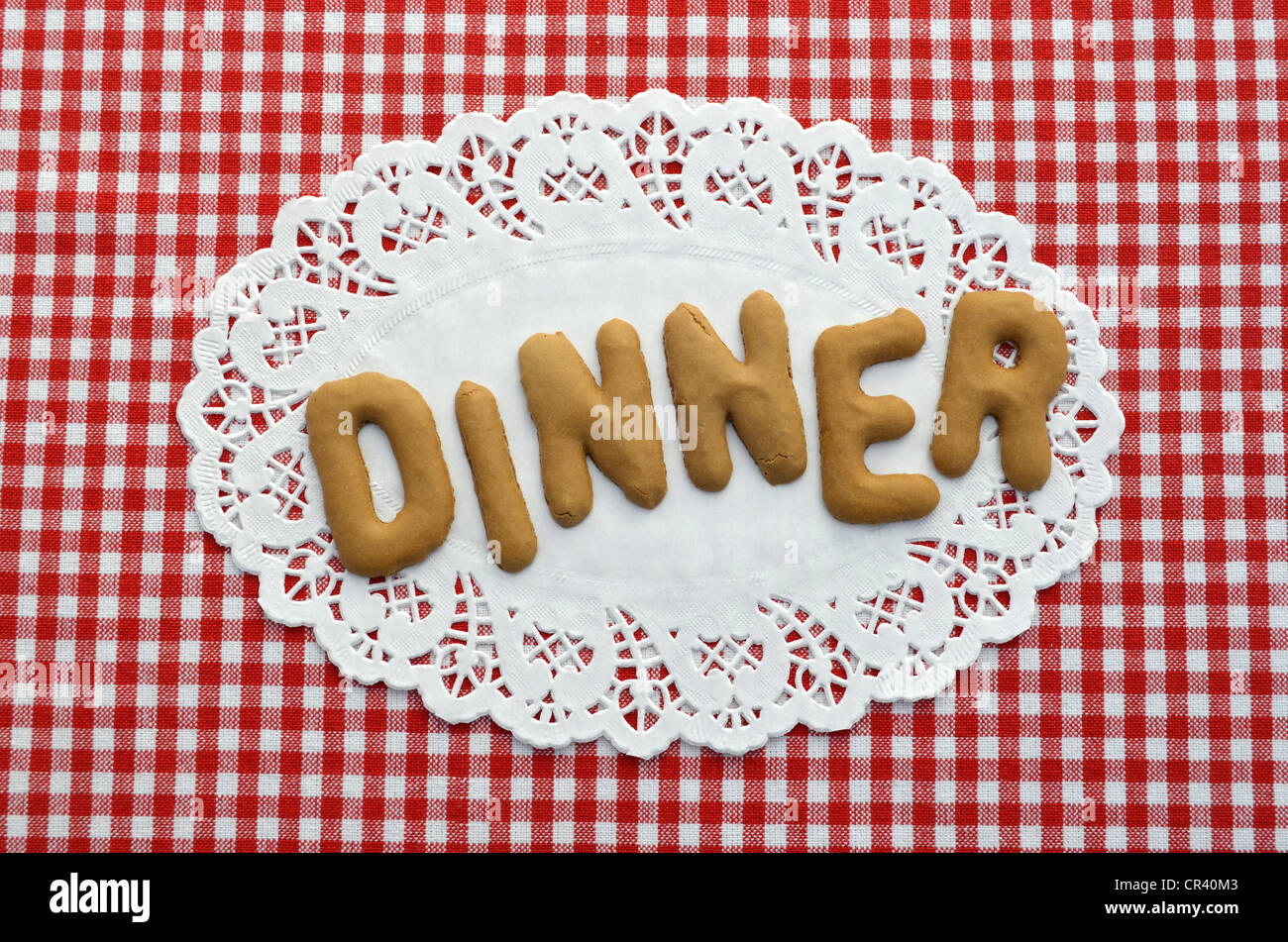 Dinner, written in alphabet biscuits on paper doily Stock Photo - Alamy